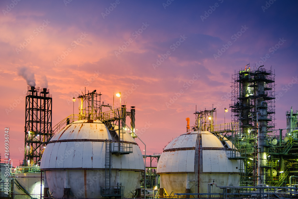 Petrochemical plant on sunset sky background with gas storage sphere ...