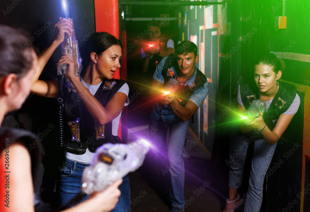 friends standing with laser guns during laser tag game Stock Photo ...