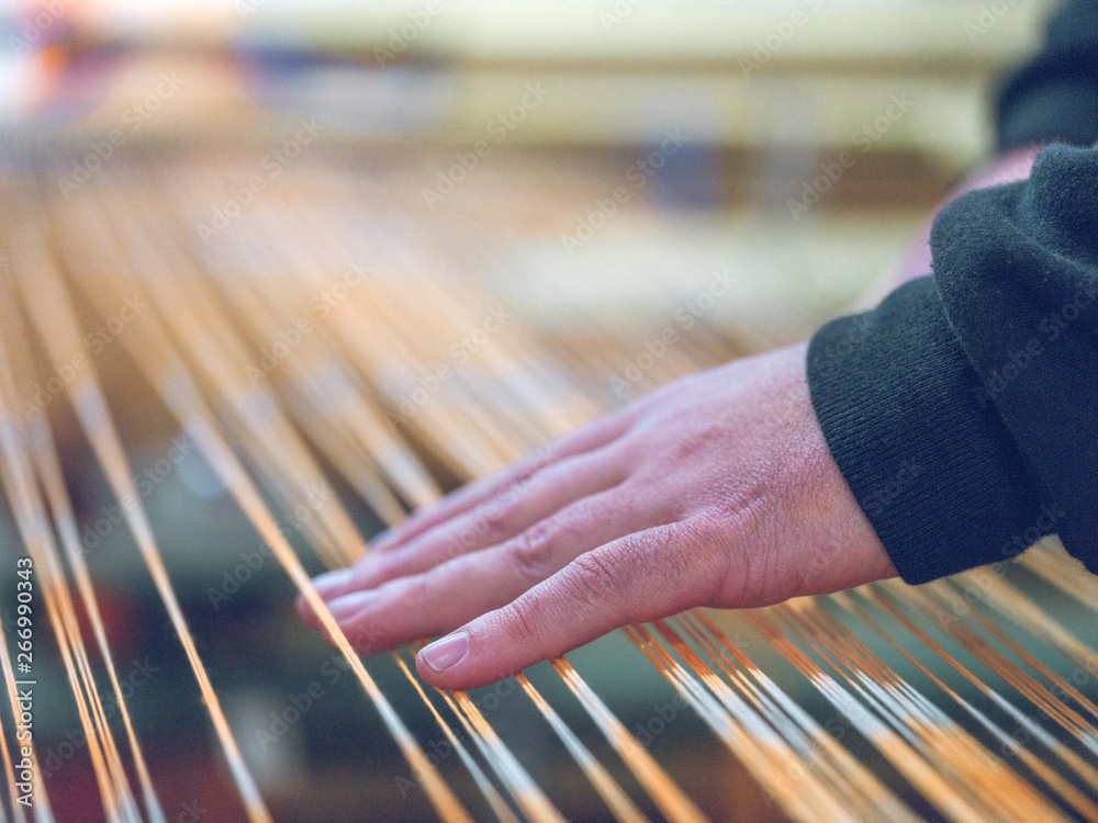 Crop weaver touching thread on loom Stock Photo | Adobe Stock