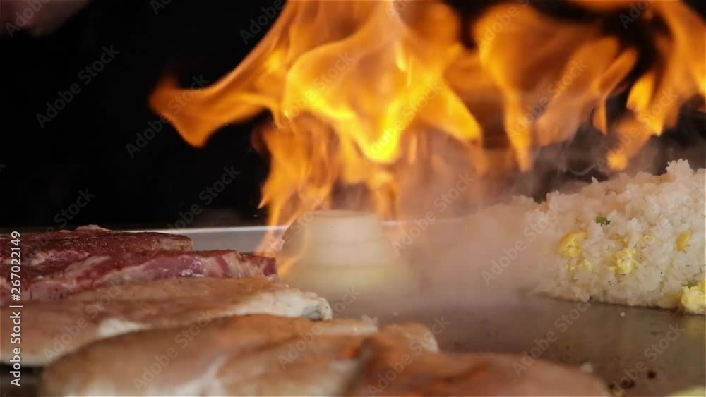 Japanese teppanyaki chef ignites a flame to make a small volcano of ...