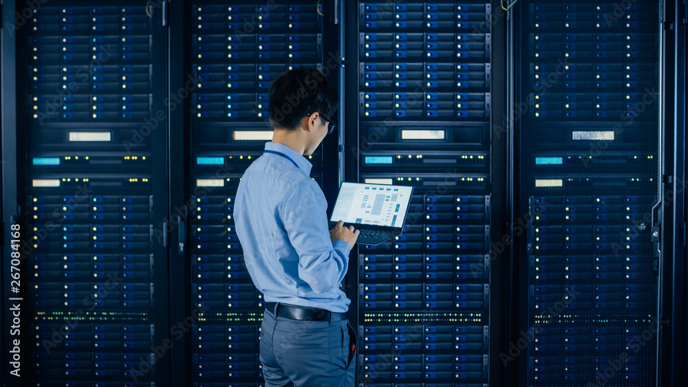 In the Modern Data Center: IT Engineer Standing Beside Open Server Rack ...