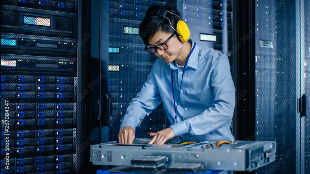 In the Modern Data Center: IT Engineer Wearing Protective Muffs ...