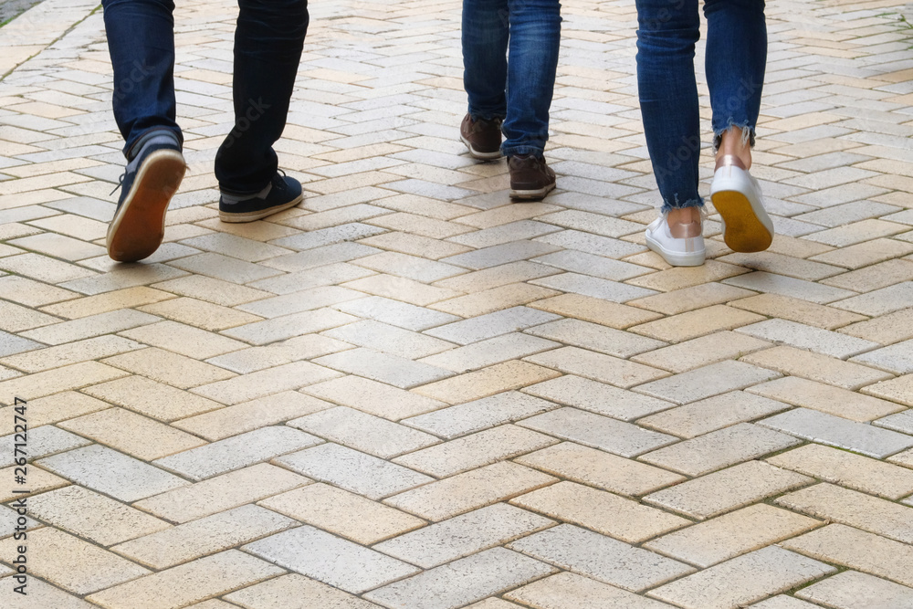 People walk along footpath. Yellow Paving slab. Pedestrian zone in the ...