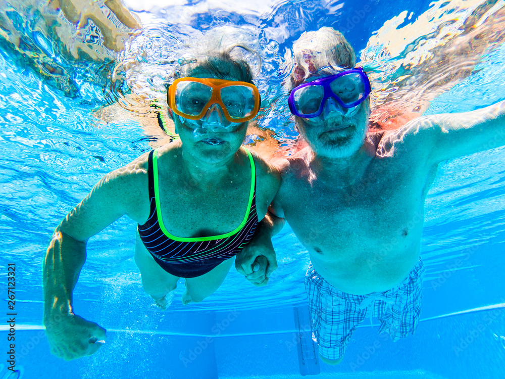 People have fun and enjoy swim underwater in the swimming pool with ...