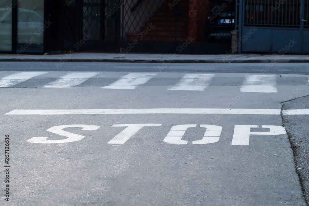 written stop sign on street,on asphalt road surface empty street at ...
