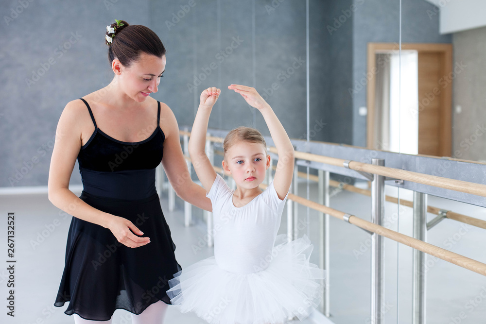 Little ballerina and ballet teacher have practice in classical dancing ...