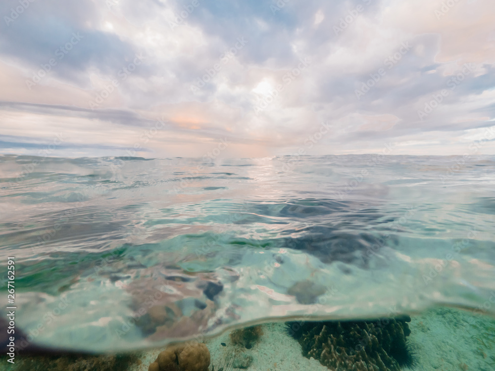 Transparent sea water and cloudy sky landscape waterline view. Coral ...