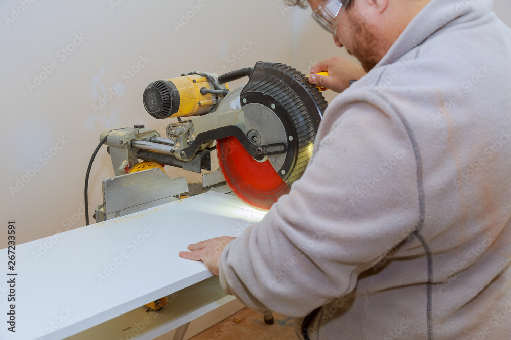 Man carpenter using circular electro saw cutting laminated white ...