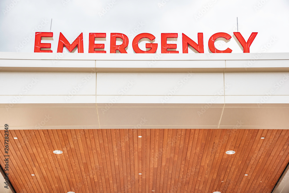 The bold and highly visible red letters of the "emergency" sign by the ...