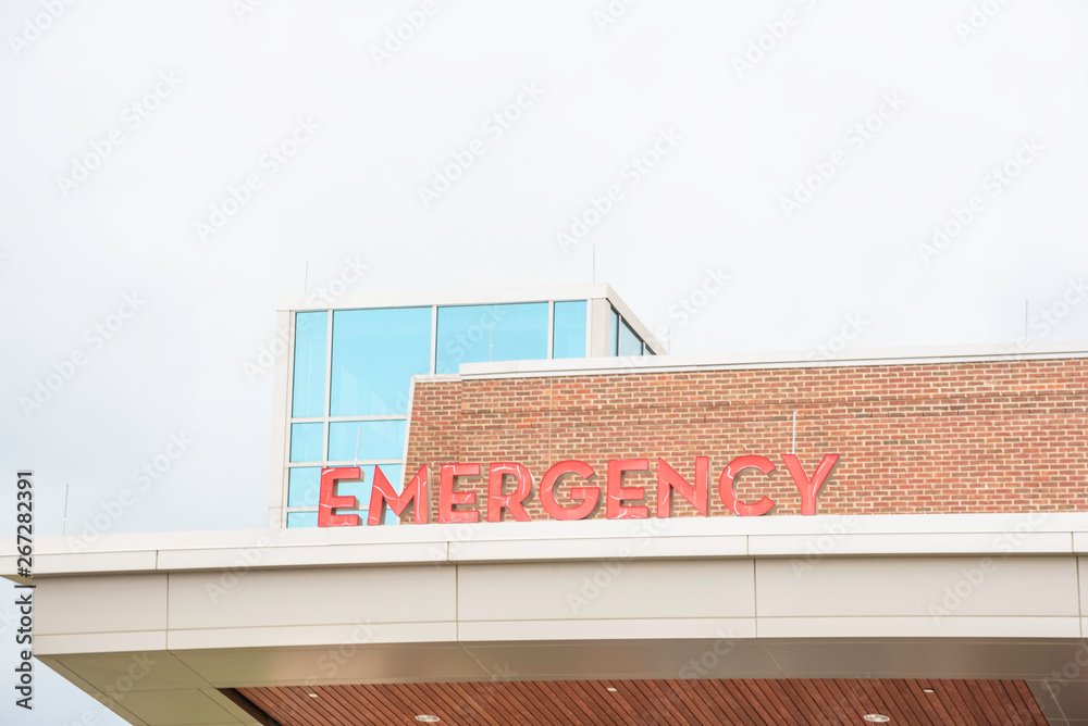 The bold and highly visible red letters of the "emergency" sign by the ...