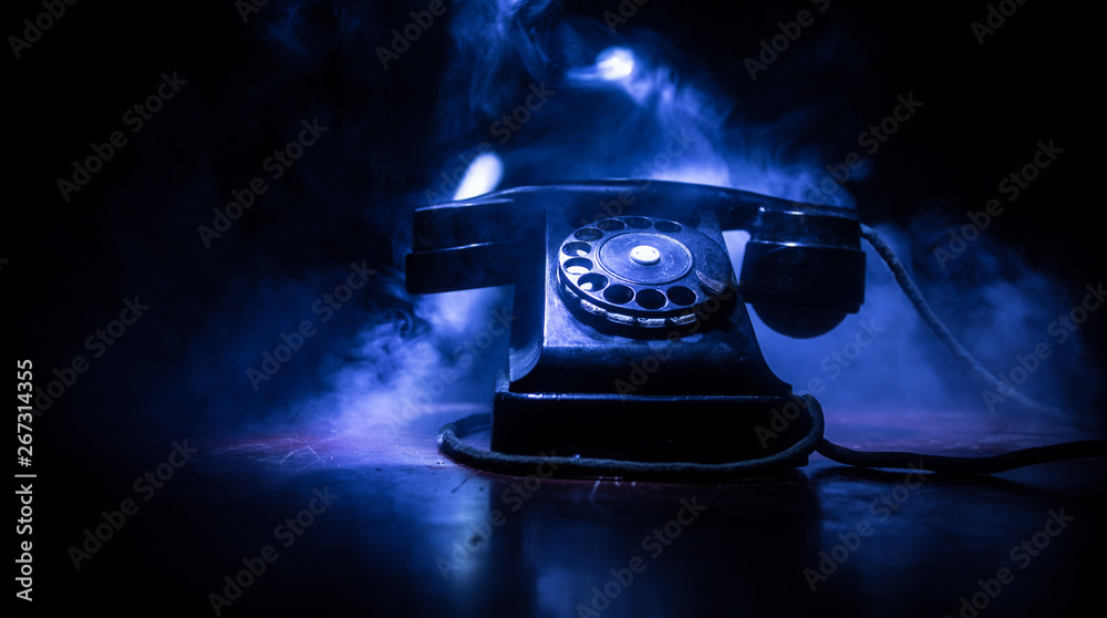 old black telephone on old wood plank with art dark background with fog ...