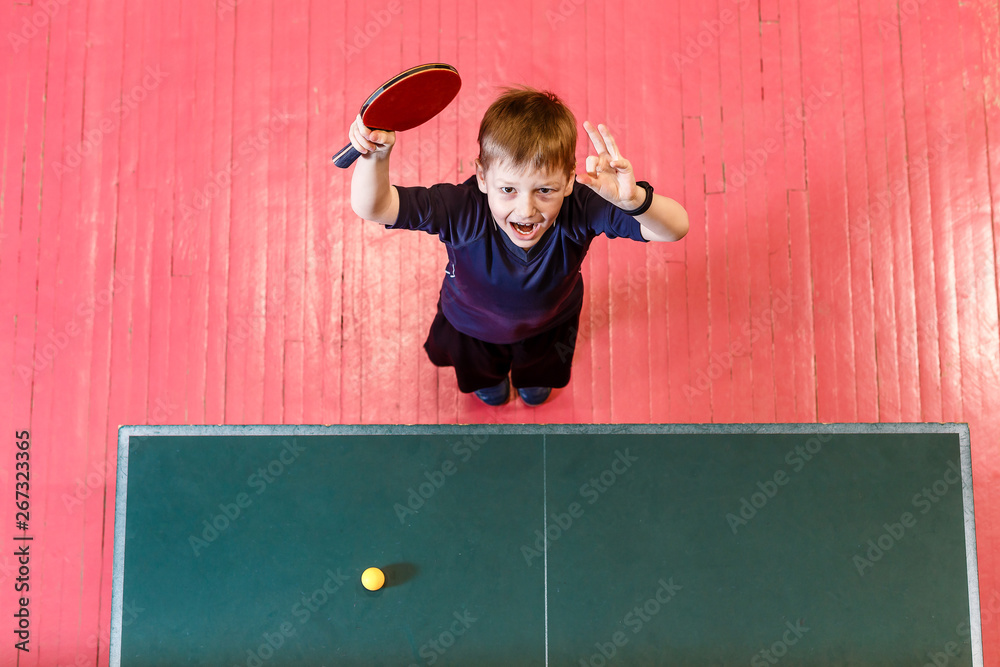 cheerful seven-year-old child enjoys winning table tennis, top view ...