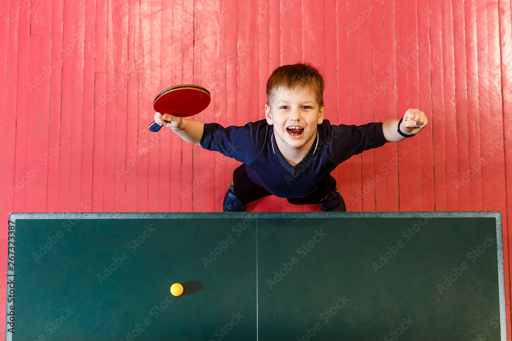 cheerful seven-year-old child enjoys winning table tennis, top view ...