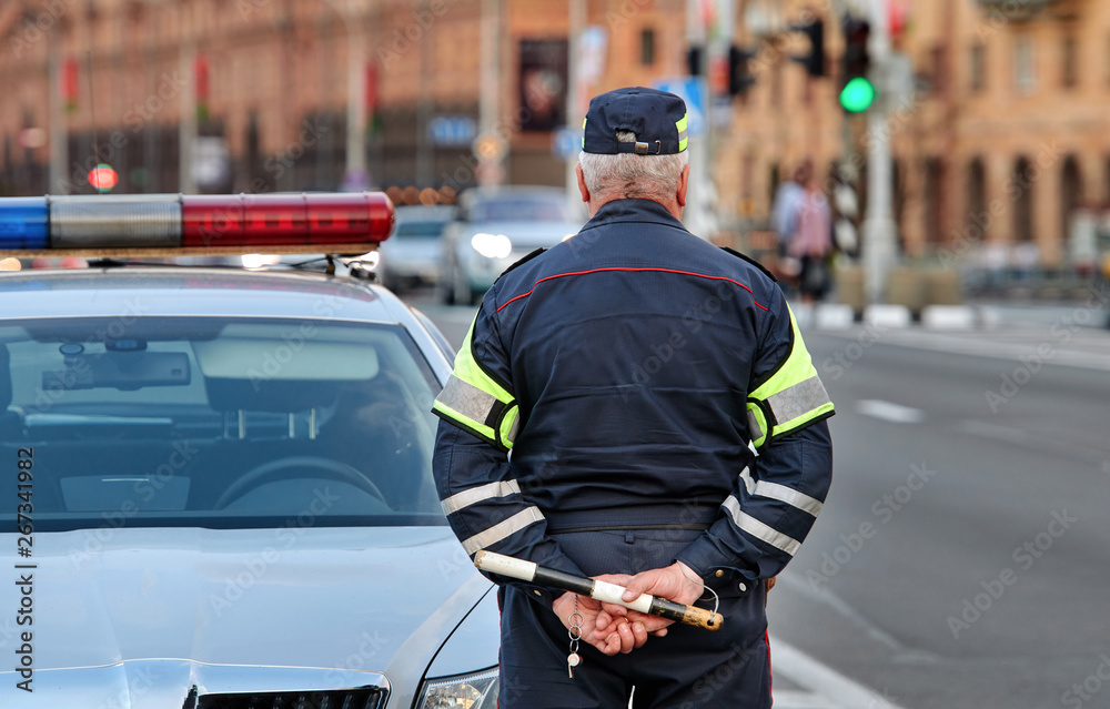 Traffic security officer in blue uniform with hands behind back ...