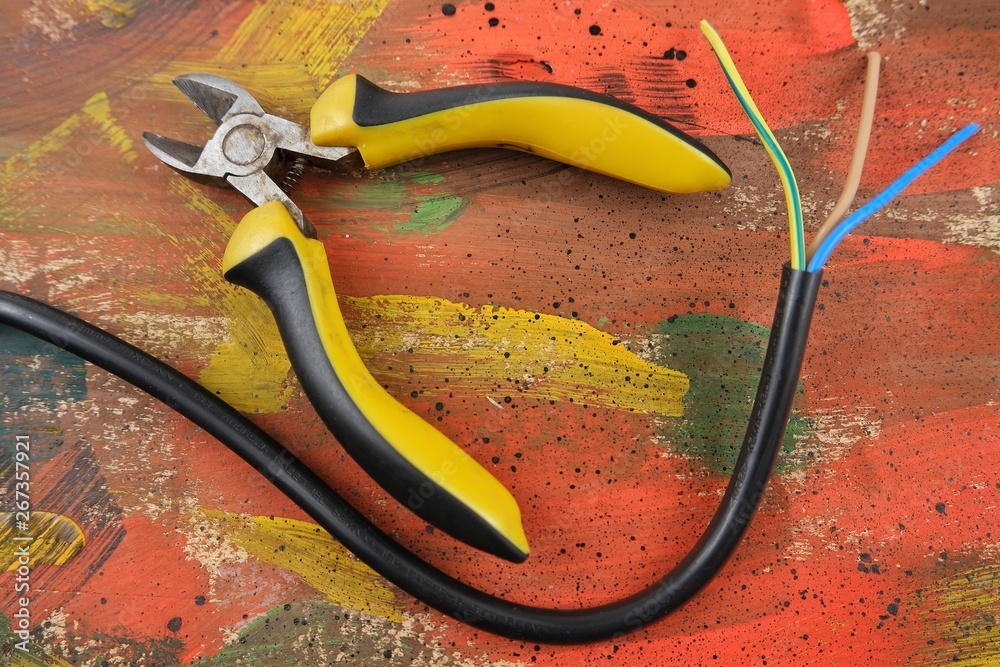 Electrical wire with conductors and electrical pliers on an abstract ...