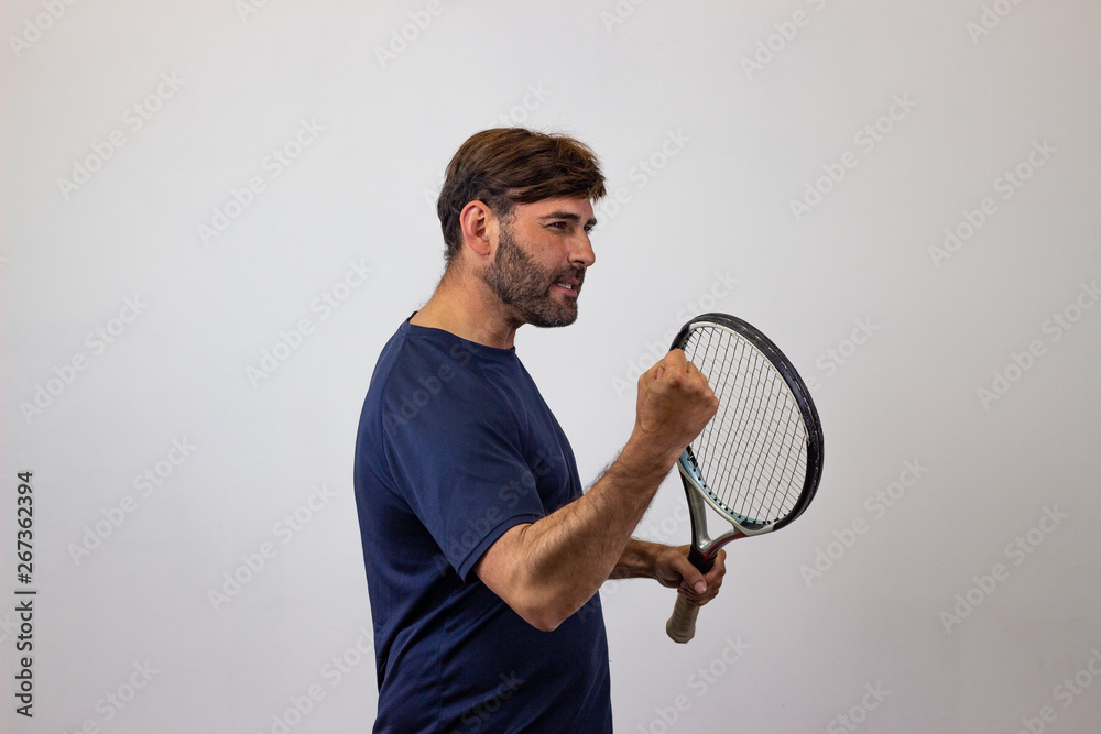 Portrait of handsome young man playing tennis holding a racket with ...