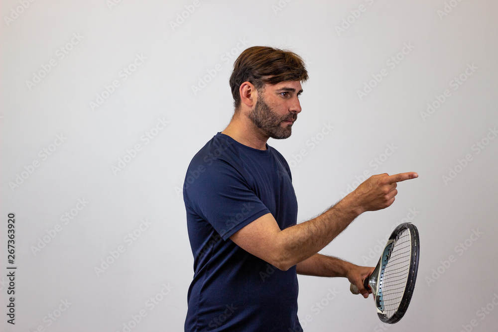 Portrait of handsome young man playing tennis holding a racket with ...