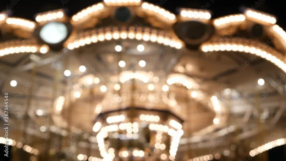 Illuminated blurred merry go round in park. Brightly illuminated ...