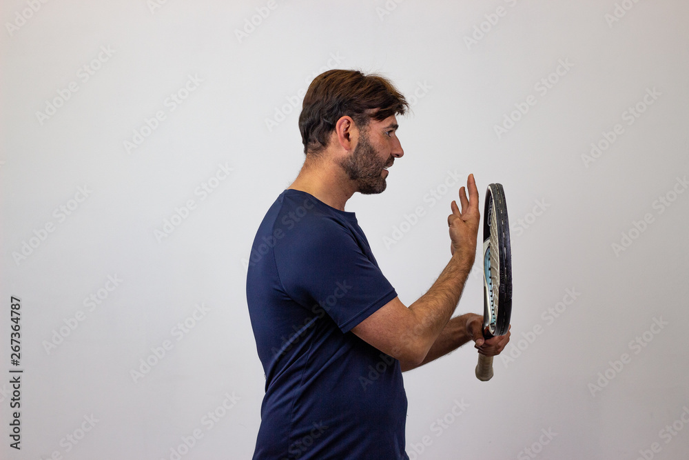 Portrait of handsome young man playing tennis holding a racket with ...