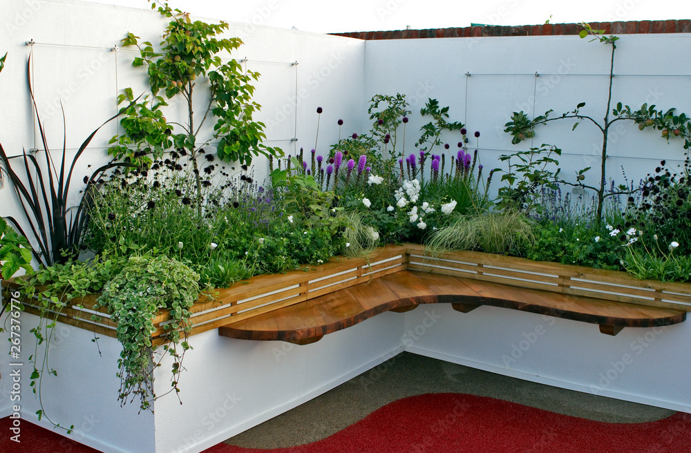 Raised corner of a terrace garden with seating, flower and fruit ...