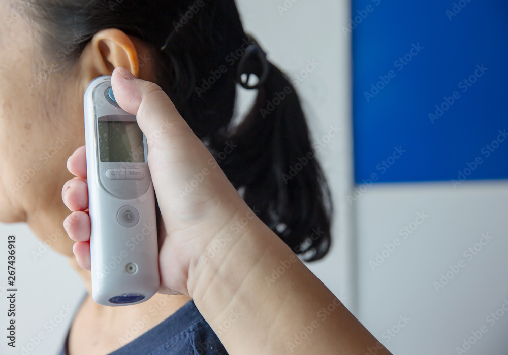 Doctor checking patient's temperature in the ear with Tympanic ...