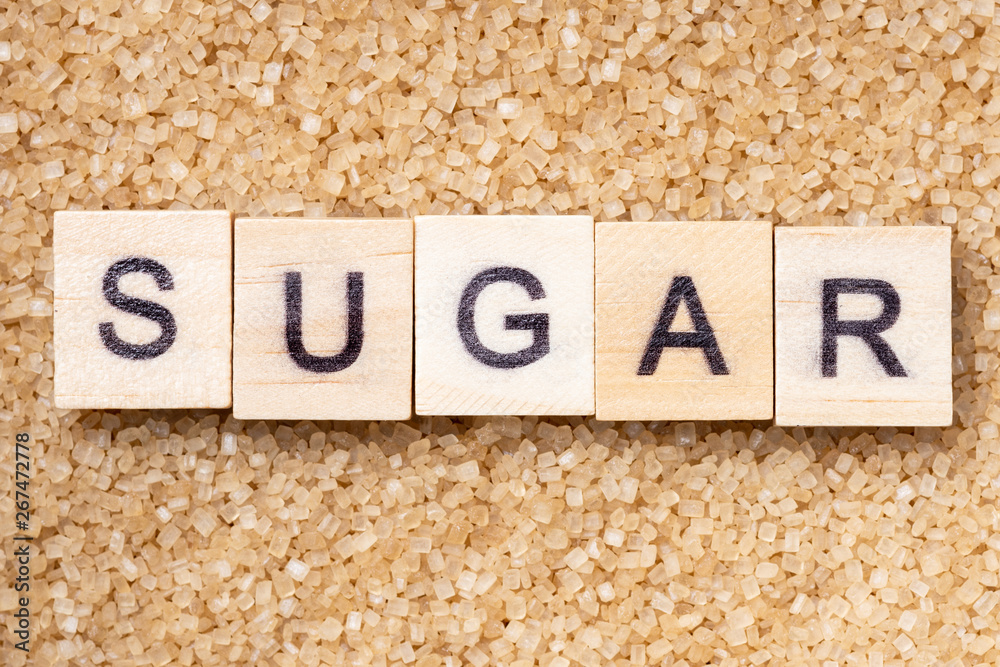 Foto de Word "sugar" on scrabble uppercase letters over a brown sugar ...