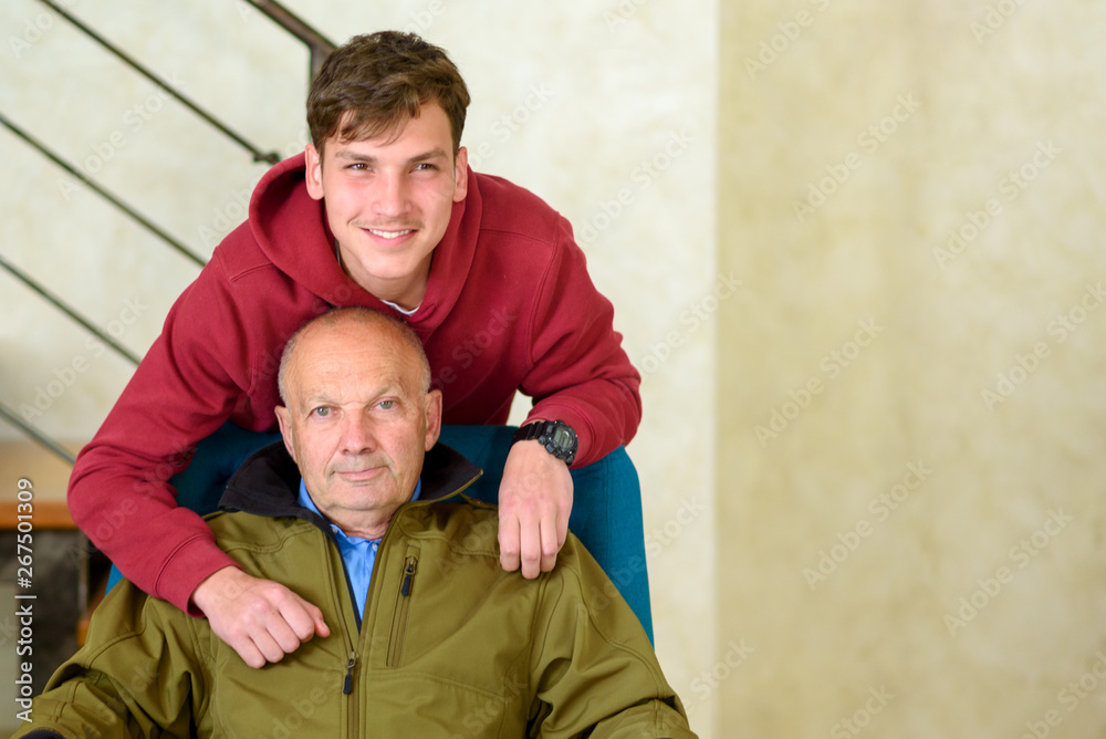 Senior father and young smiling son looking away in a home. Happy old ...