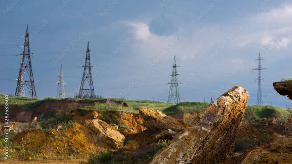 Stones in the foreground. Quarry and high-voltage towers.Powerful lines ...