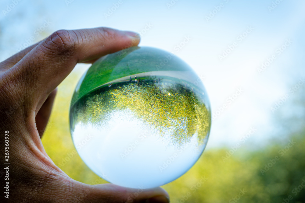 A hand holding a crystal ball for optical illusion. Known as an ...
