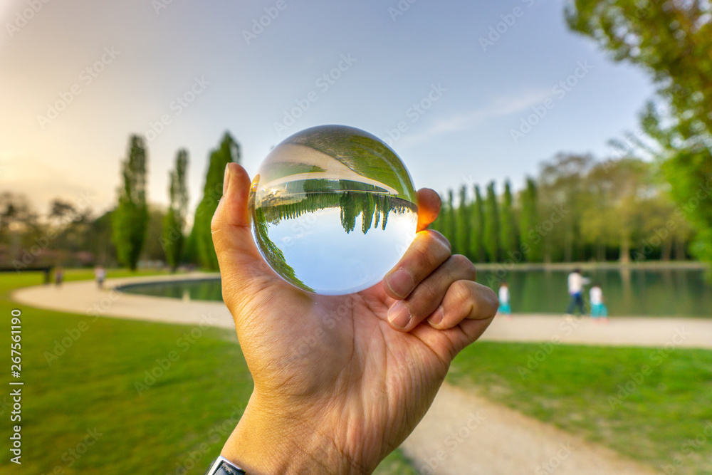 A hand holding a crystal ball for optical illusion. Known as an ...