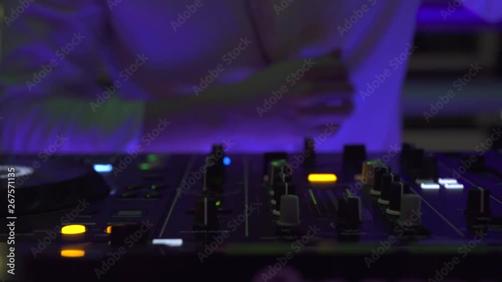DJ controller and music console in colorful light at dance party in ...
