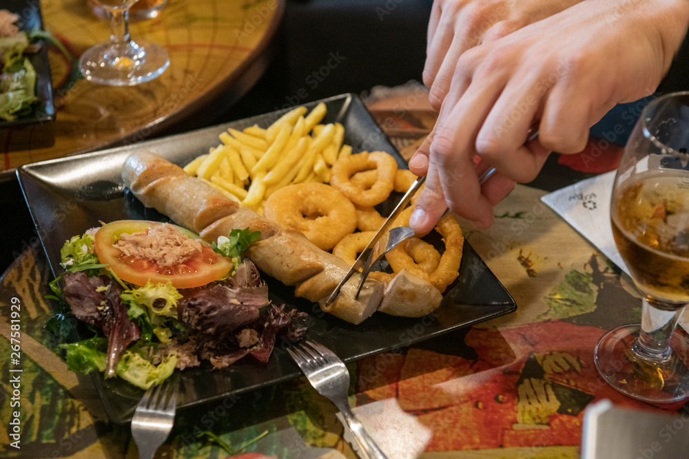 Gente comiendo en restaurante con plato de salchichas, ensalada Stock ...