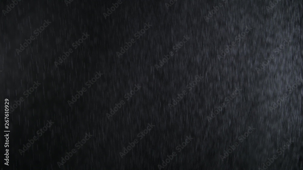 4k Heavy angled rain falling in front of the camera against black ...