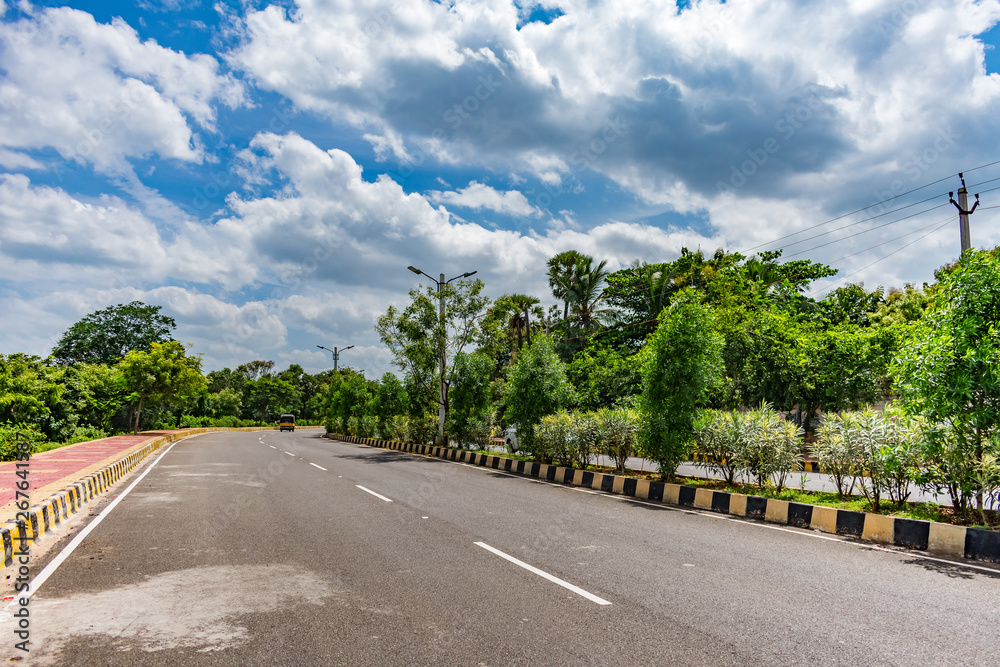 straight road of national highway with trees plantation on center of ...