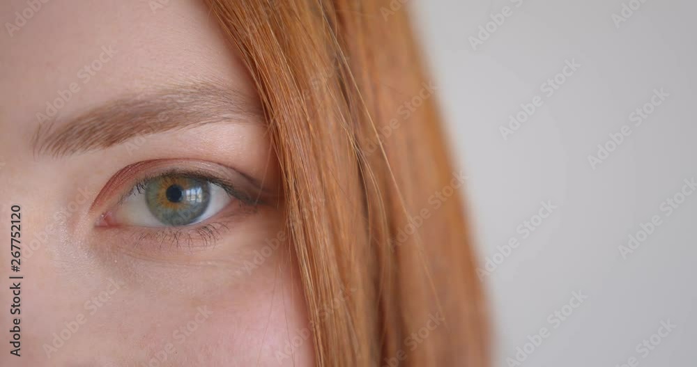 Close-up one eye portrait of beautiful ginger model blinking watching ...