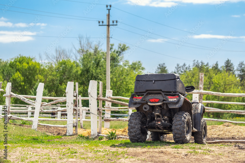 ATV quad bike vehicle standing near wooden fence at farm or horse ...