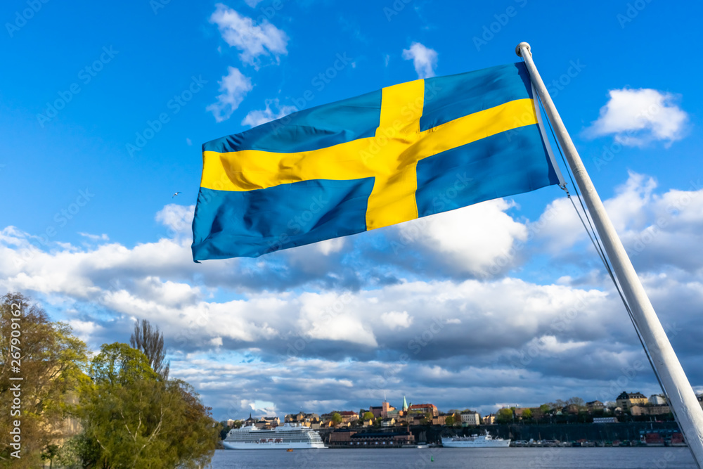 Swedish flag against blue sky with white clouds. Beautiful swedish flag ...