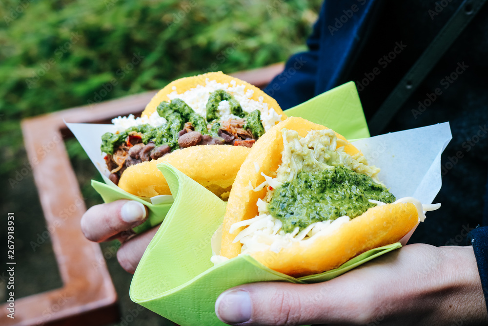 Woman holding two fried Arepas, a typical Venezuelan Street Food with ...