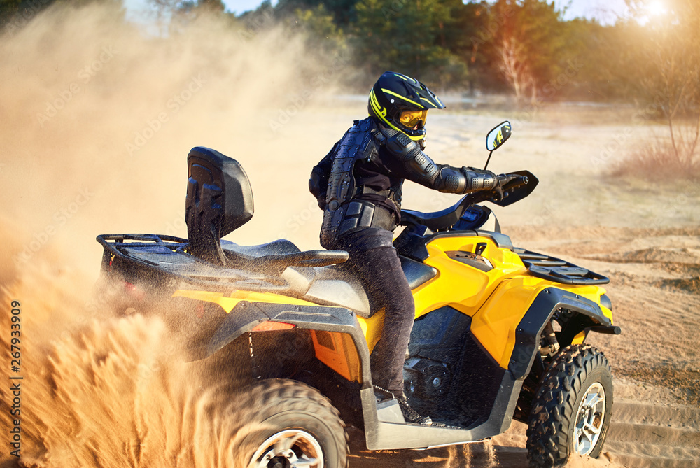 Racing powerful quad bike on the difficult sand in the summer. Stock ...