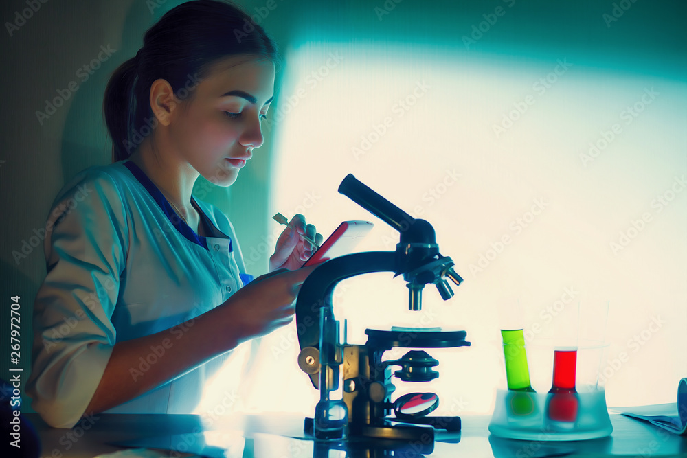 Student girl looking in a microscope, science laboratory concept ...