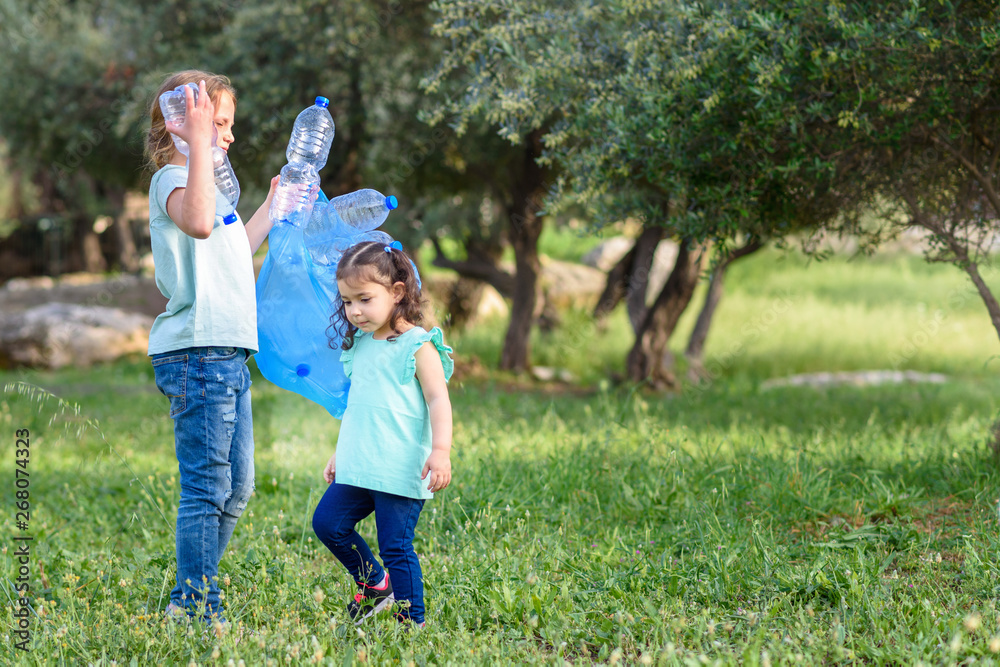 Two kids volunteer cleaning plastic pollution in summer park. Children ...