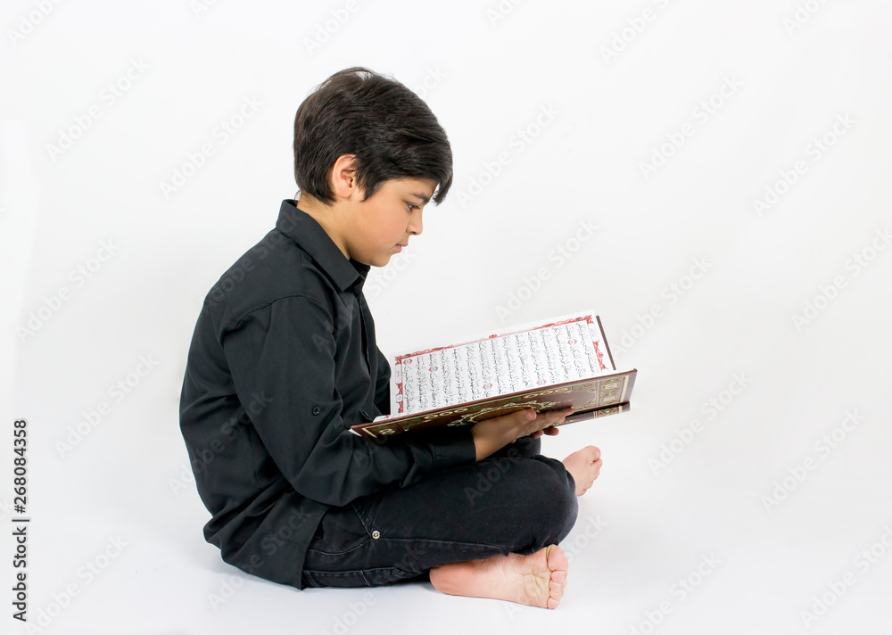 Muslim young boy reading Quran, the holy book of Islam Stock Photo ...