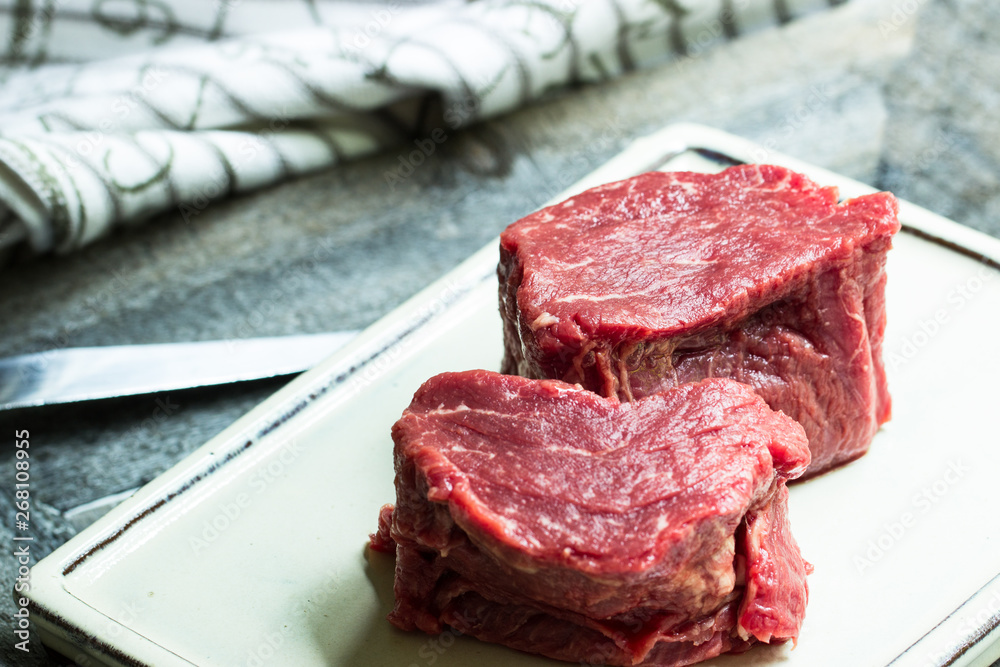 Rinderfilet vom Simmentaler Rind, roh afu einer Platte mit Messer und ...