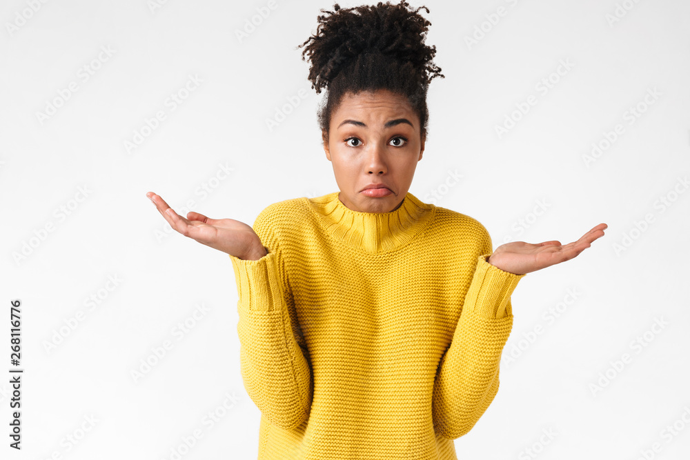 Beautiful young african confused woman posing isolated over white wall ...