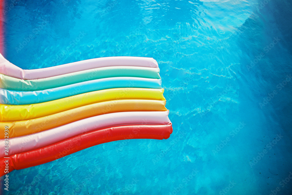 kids on rainbow floaty in blue pool on film Stock Photo | Adobe Stock