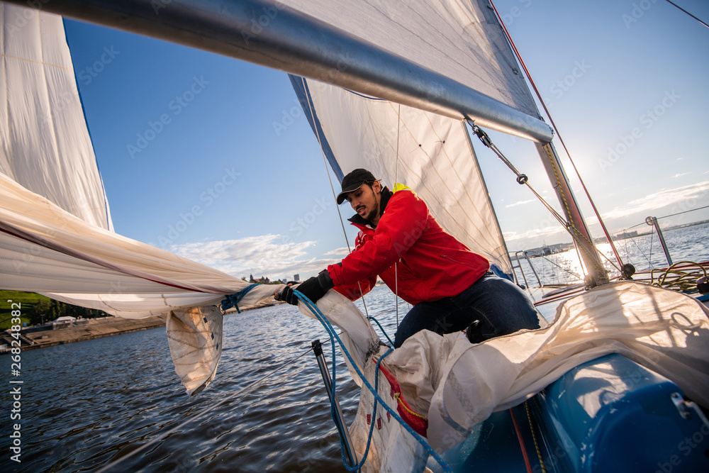 Yacht sailor pulling rope. Man working on sailboat. Stock Photo | Adobe ...