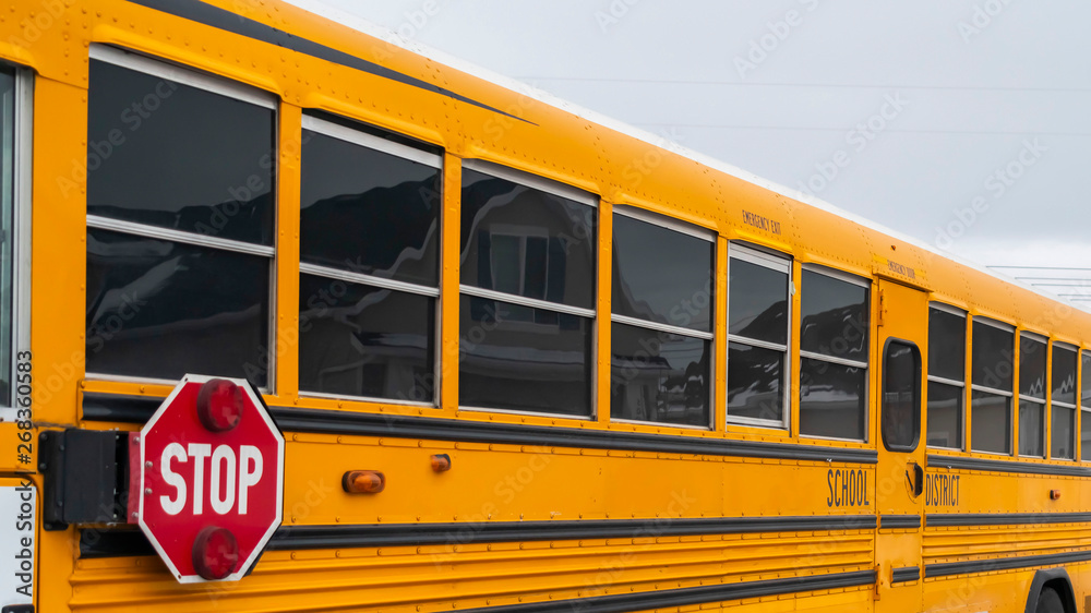 Panorama Side view of a school bus on a road passing through snowy ...