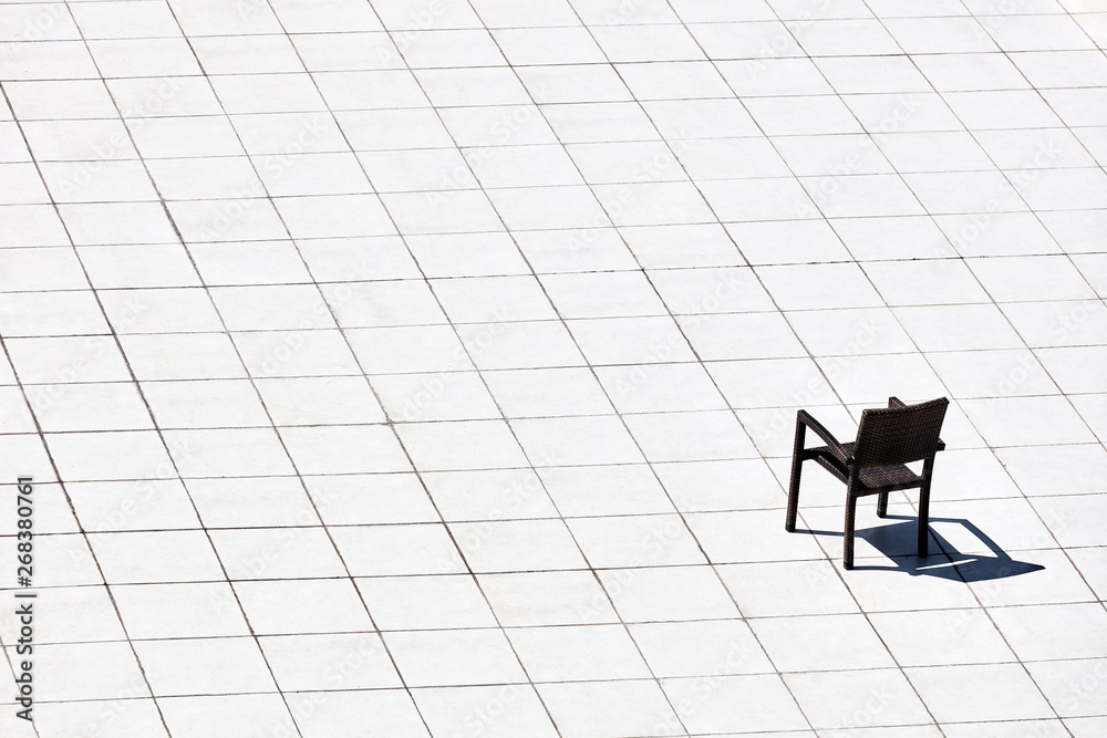 Overhead view of a chair on white tile floors of an outdoor terrace ...