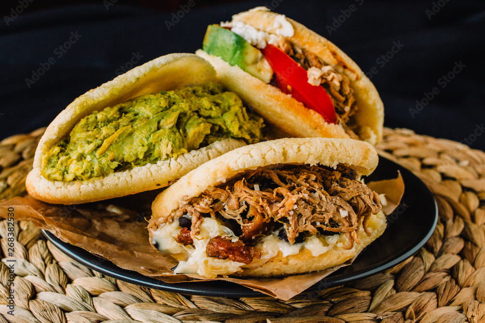 Venezuelan arepas on a black background, made with maize and filled ...