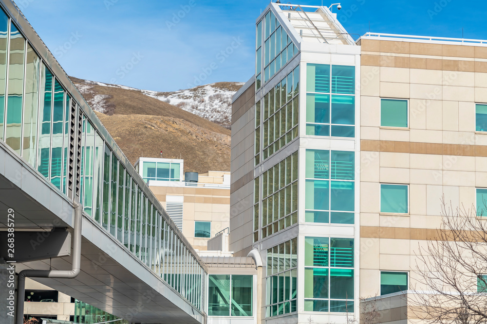Sunny day view of a modern building exterior with a glass walled ...